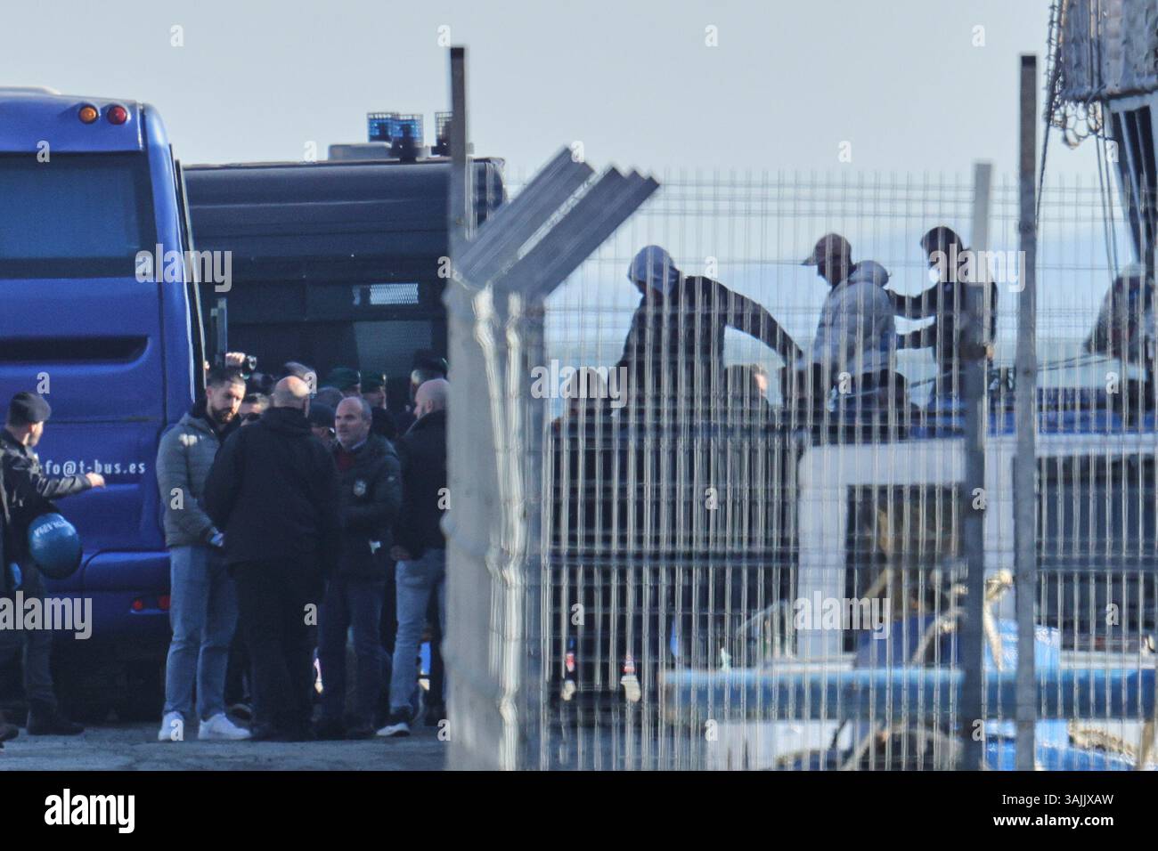 A migrant escorted by police officers disembarks the Italian navy ship ...