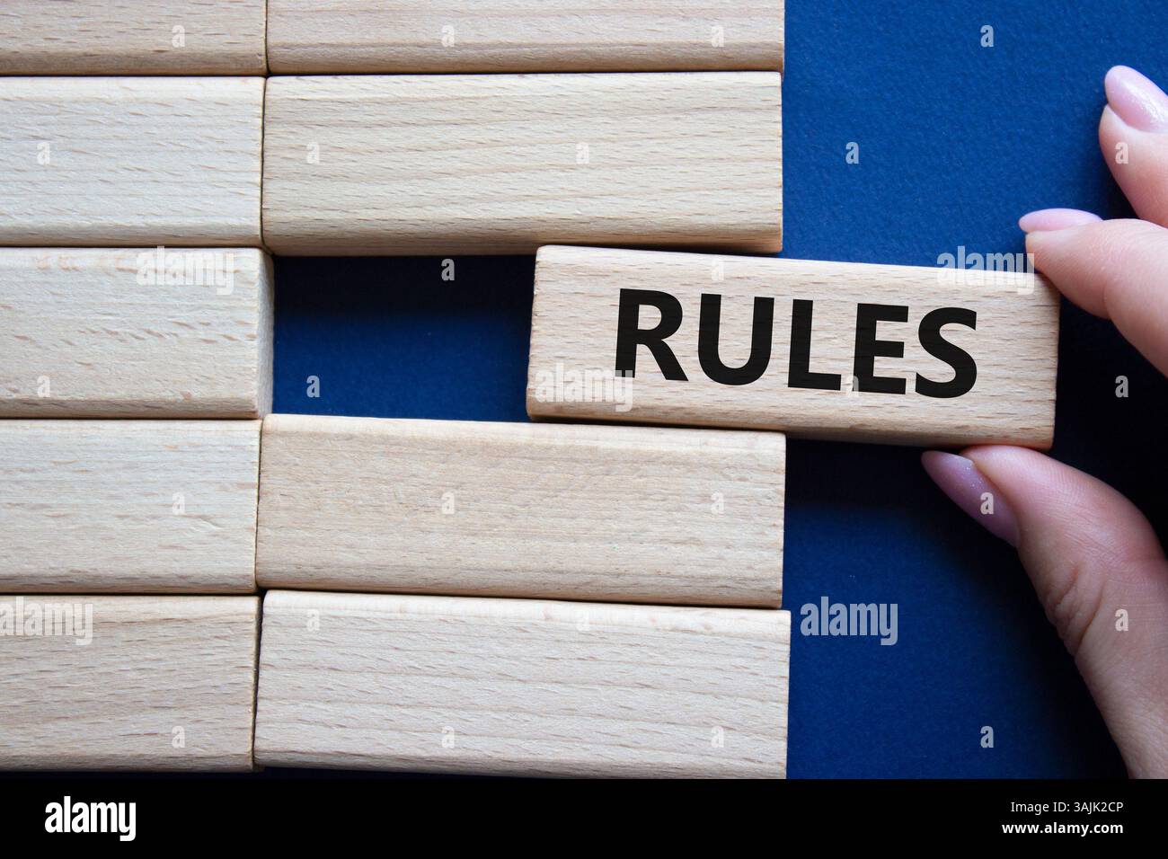 Rules symbol. Wooden blocks with word Rules. Businessman hand ...
