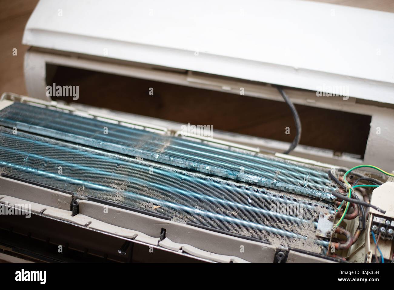 Dirty and disassembled wall-mounted air conditioner unit, showing ...