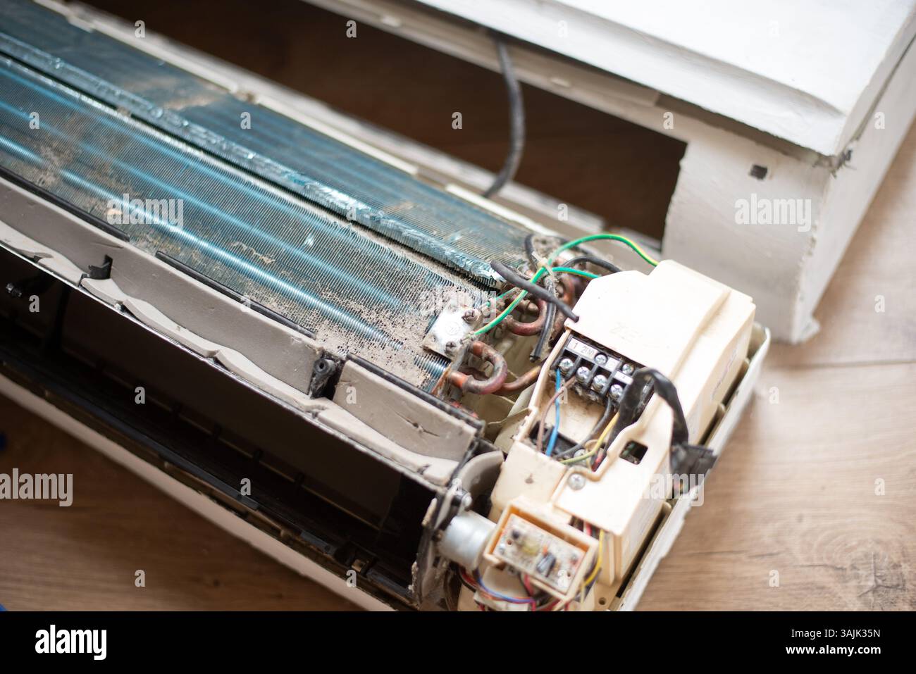 Dirty and disassembled wall-mounted air conditioner unit, showing internal components and dust ...