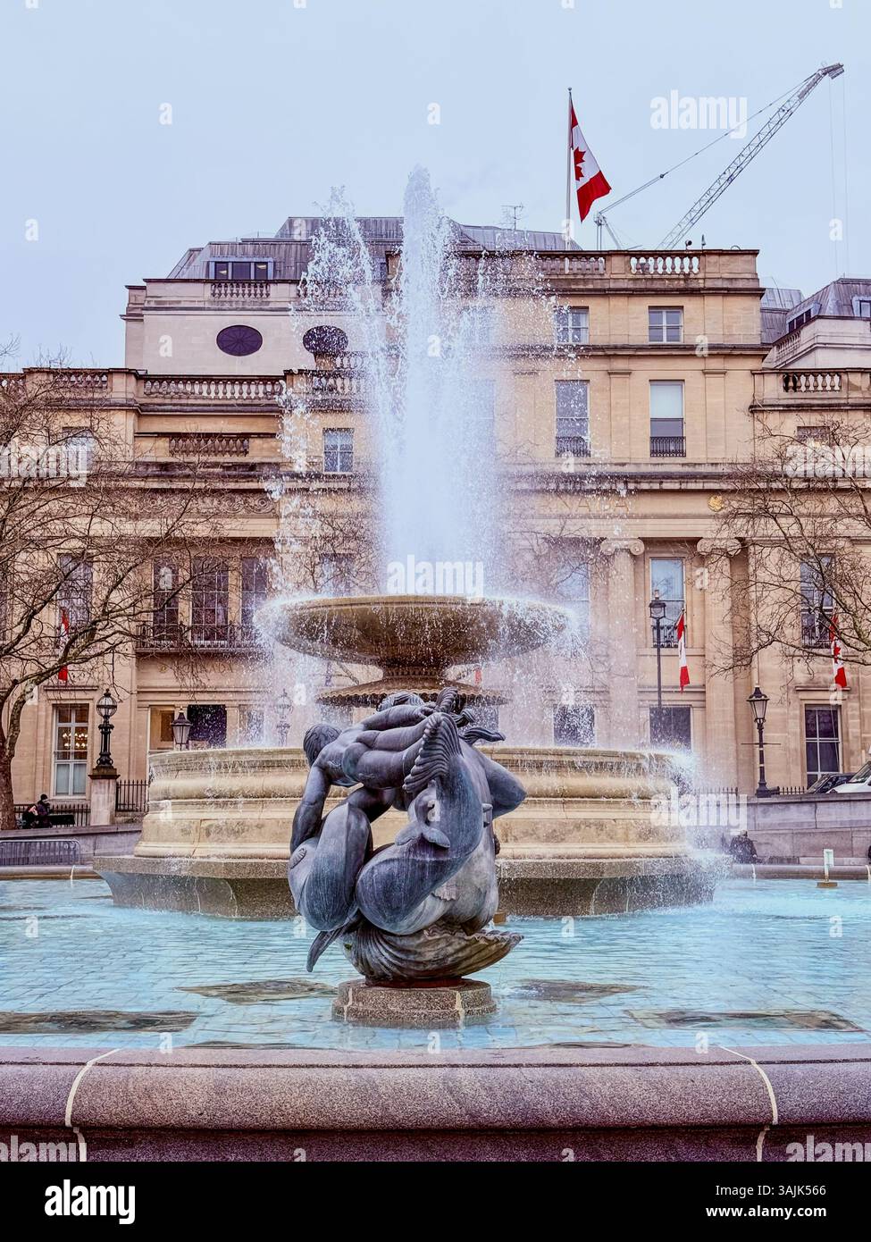 A striking view of one of Trafalgar Square's iconic fountains, framed ...