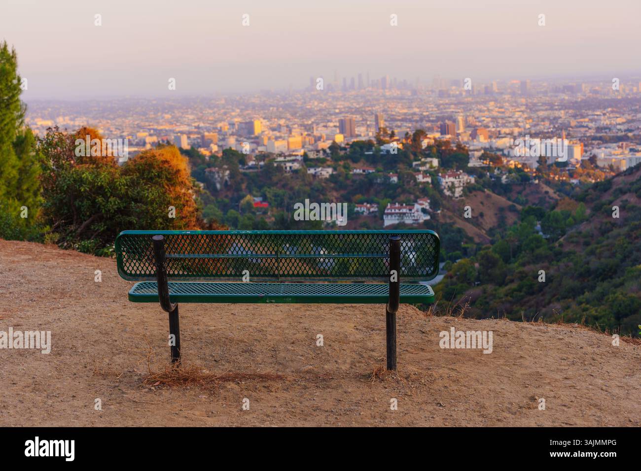 Solitary green bench sits on a dirt path at Runyon Canyon Park ...