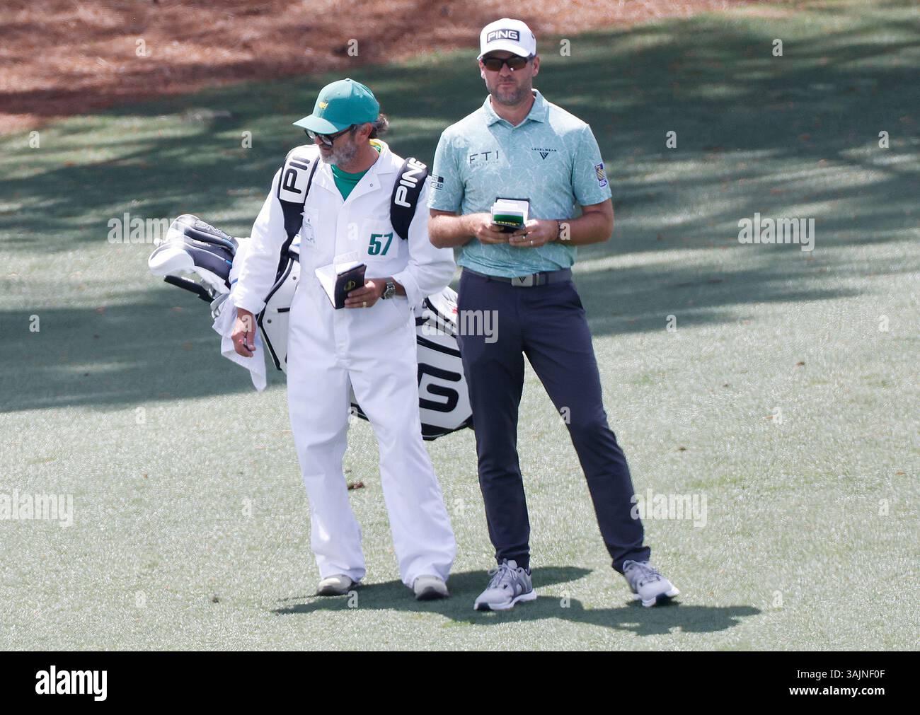 Corey Connors of Canada checks his playbook as he approaches the ninth ...