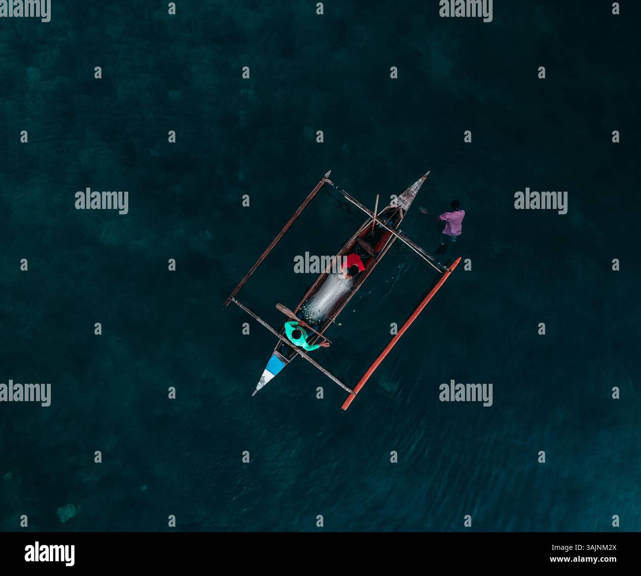 Aerial view of a vibrant outrigger boat in the Philippines, cruising ...