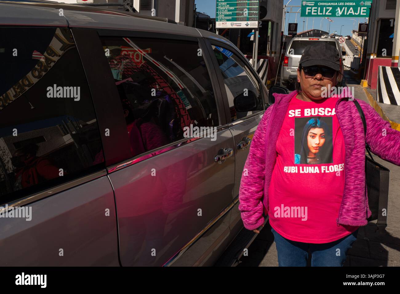 A woman wears a shirt with a missing person photo during a protest at ...