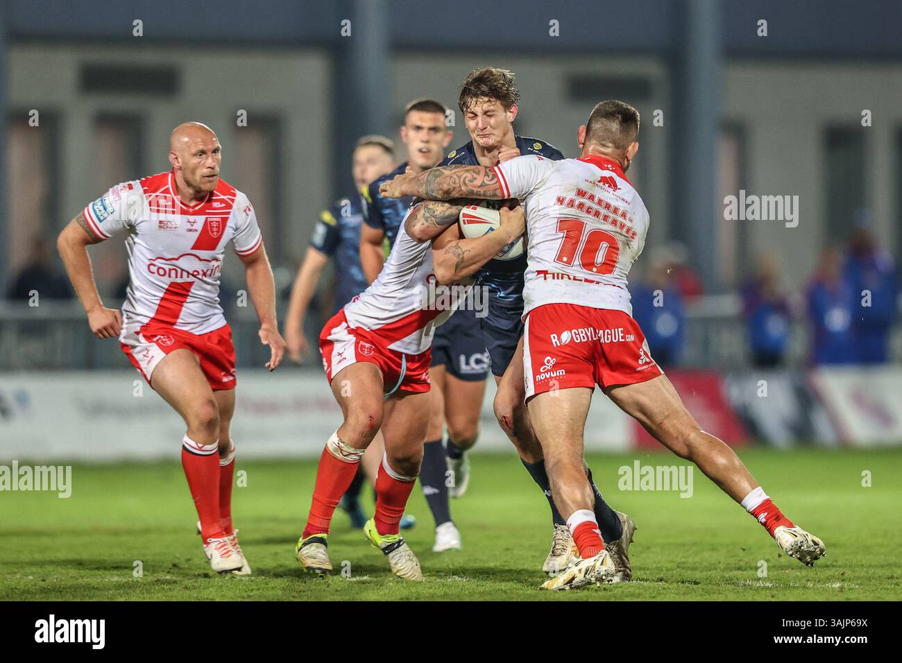 Harvey Makin of Wigan Warriors is tackled by Kaide Ellis of Wigan ...