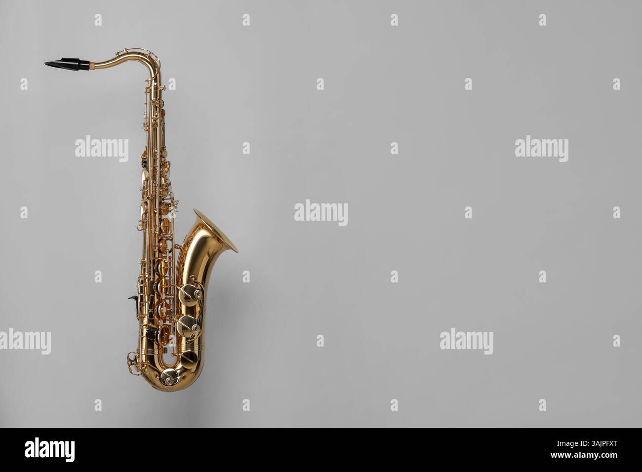 Golden saxophone on light grey background. Space for text Stock Photo ...