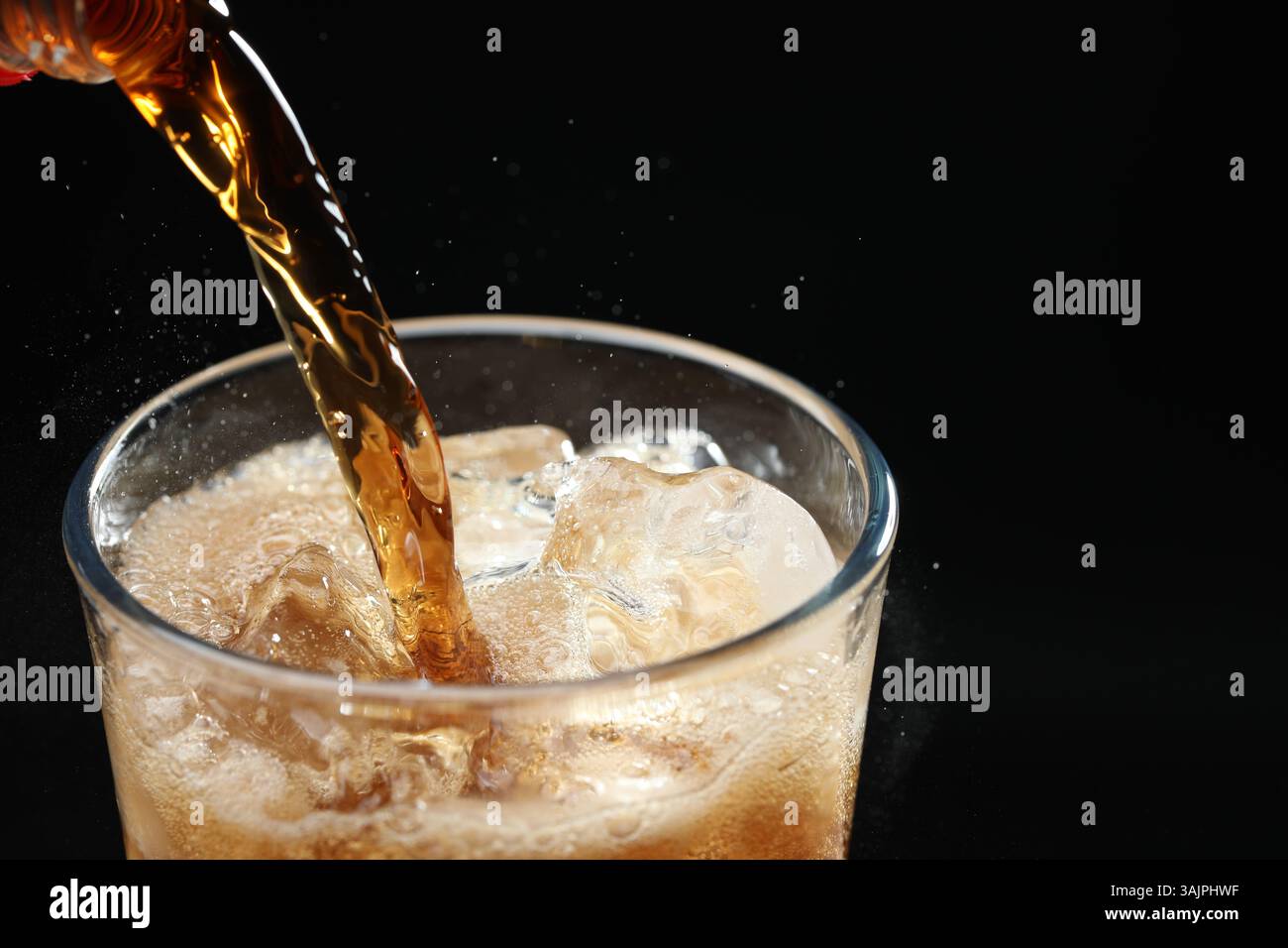 Pouring refreshing cola into glass on black background, closeup Stock ...