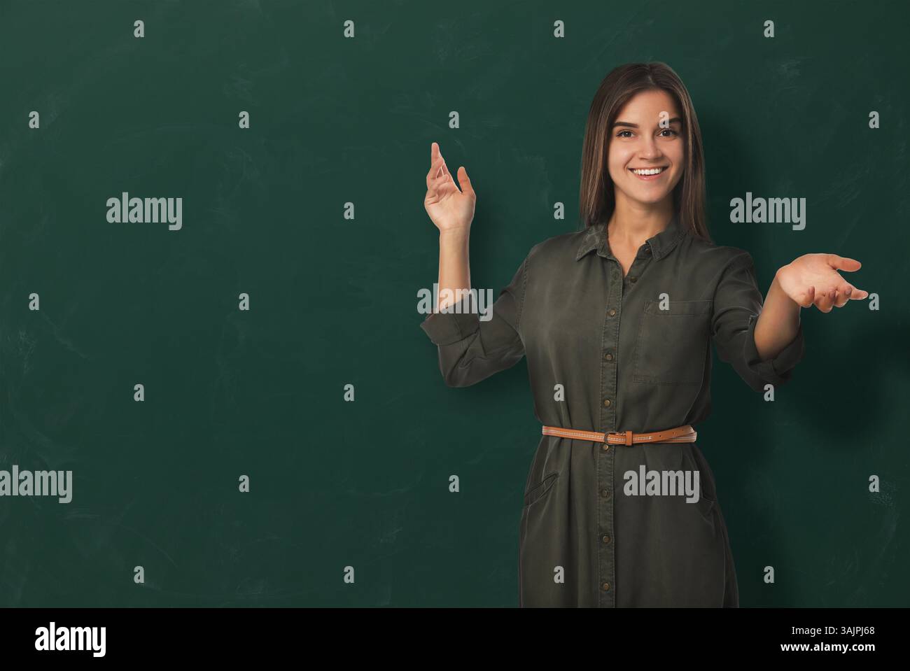 Teacher pointing at green chalkboard, space for text Stock Photo - Alamy