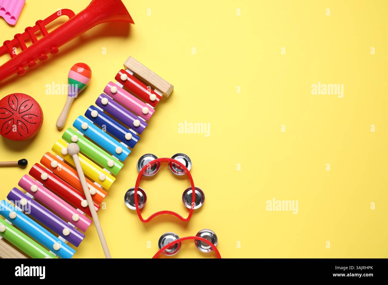 Flat lay composition with different toy musical instruments on yellow ...