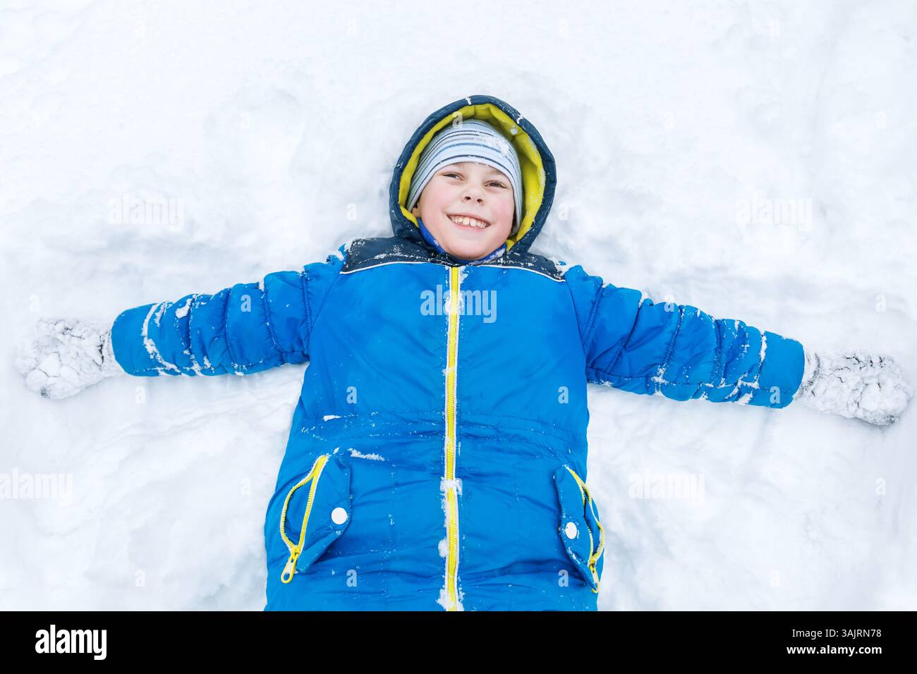 Joyful Child Making Snow Angel in Bright Blue Winter Jacket Stock Photo ...