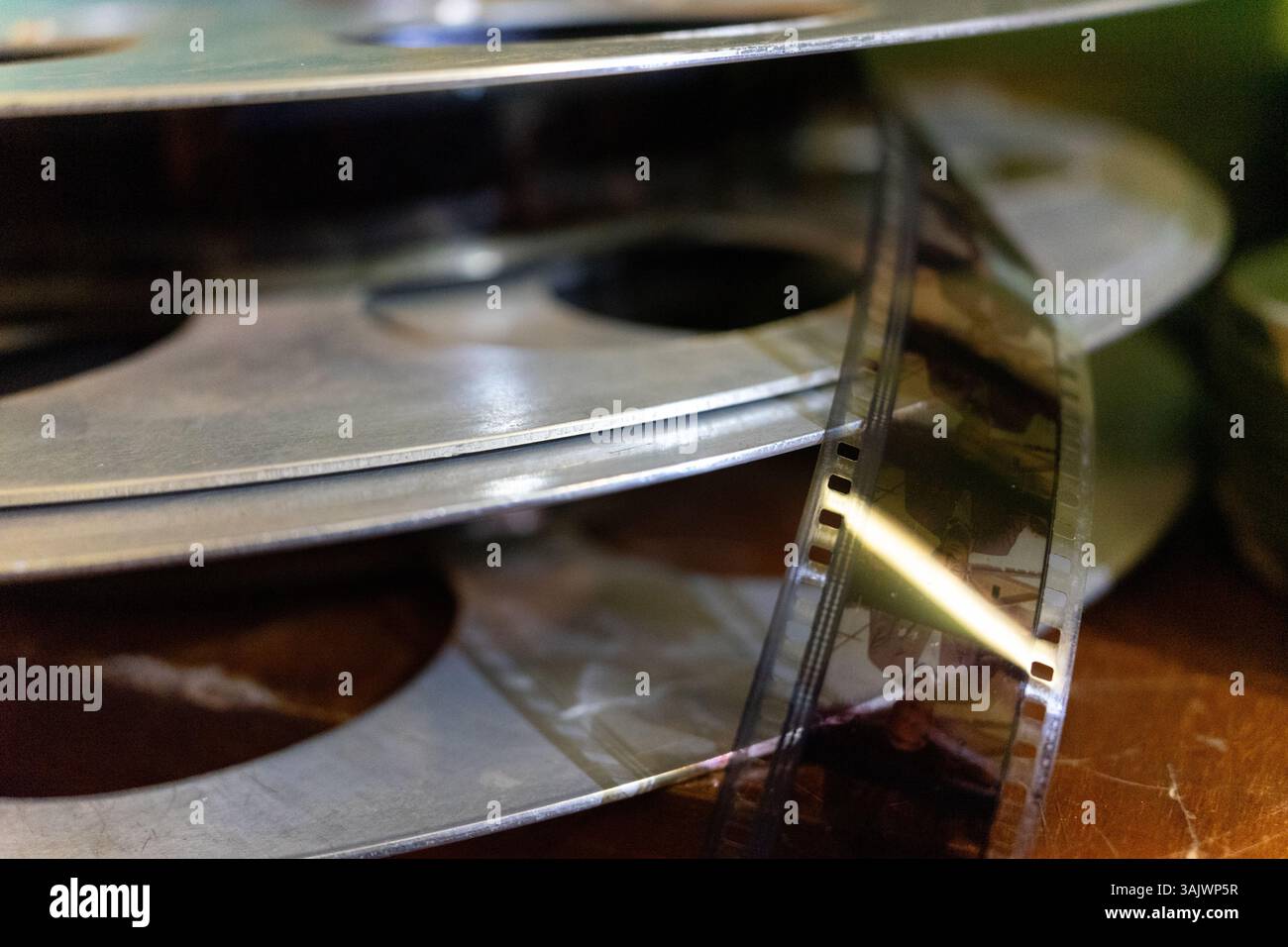 Old film reels are arranged on a wooden table, highlighting the ...