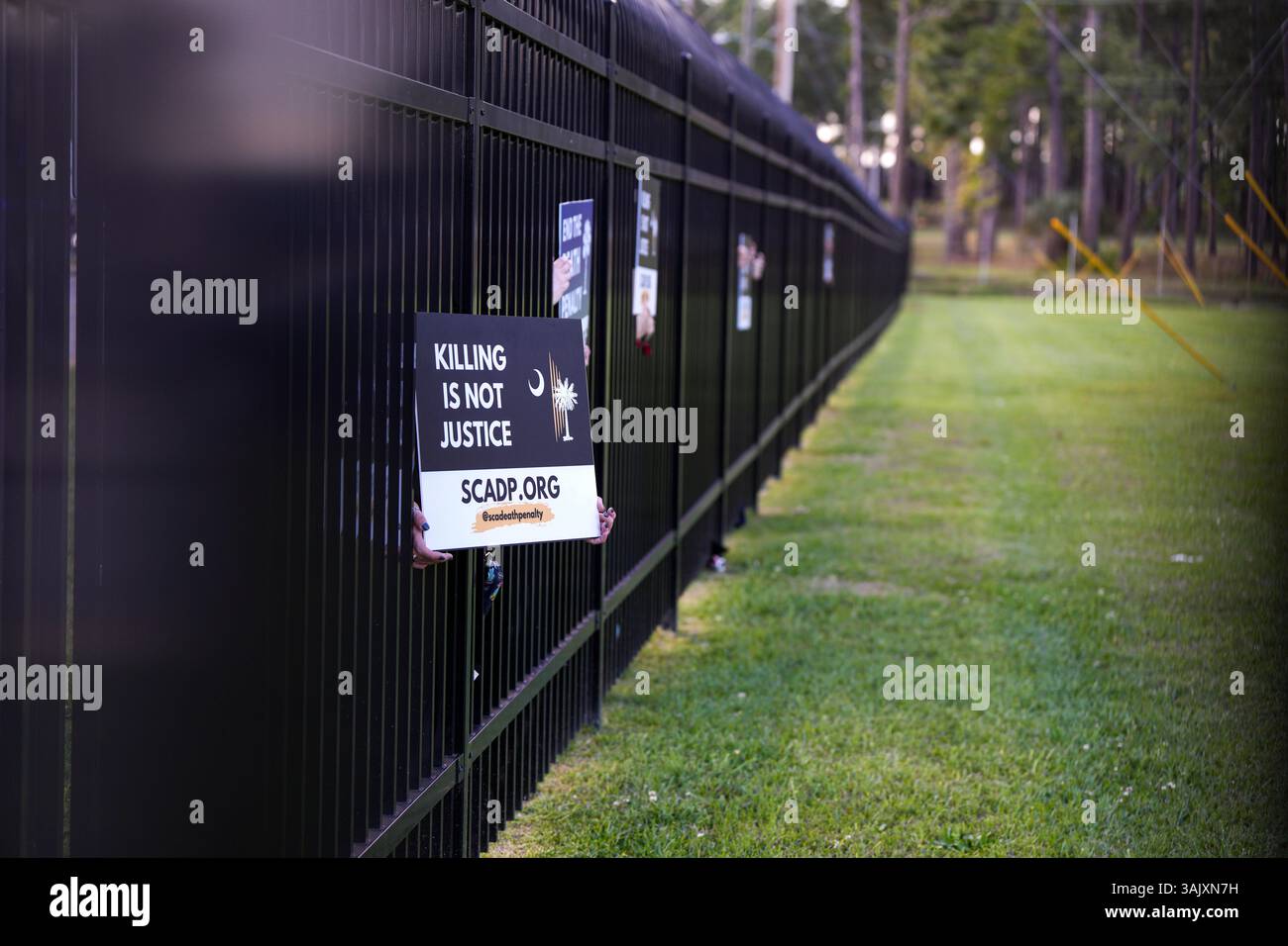 Protestors put their signs inside the Department of Corrections fence ...