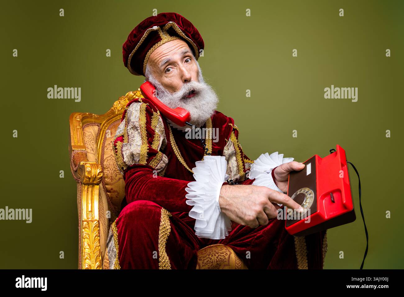 A stylish nobleman in vintage attire uses a rotary dial telephone ...