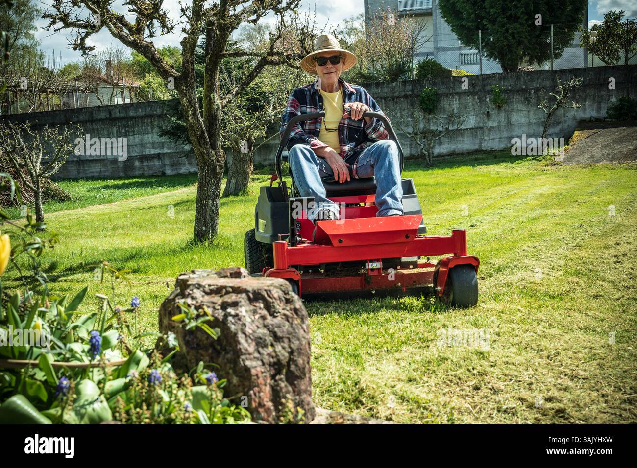 Man on riding lawn mower Stock Photo - Alamy