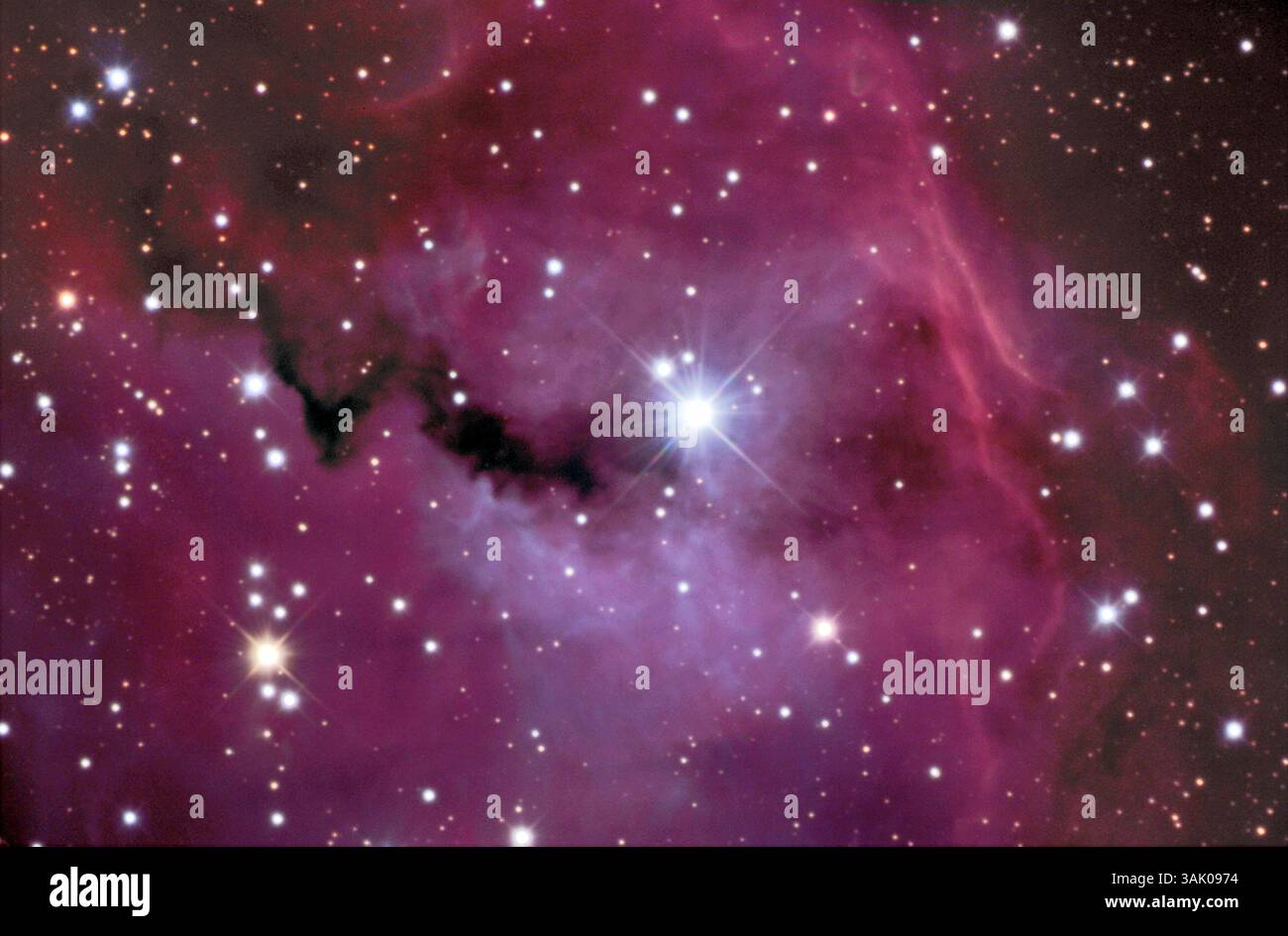 Emission nebula NGC 2327. The region glows pink as the hydrogen gas it ...