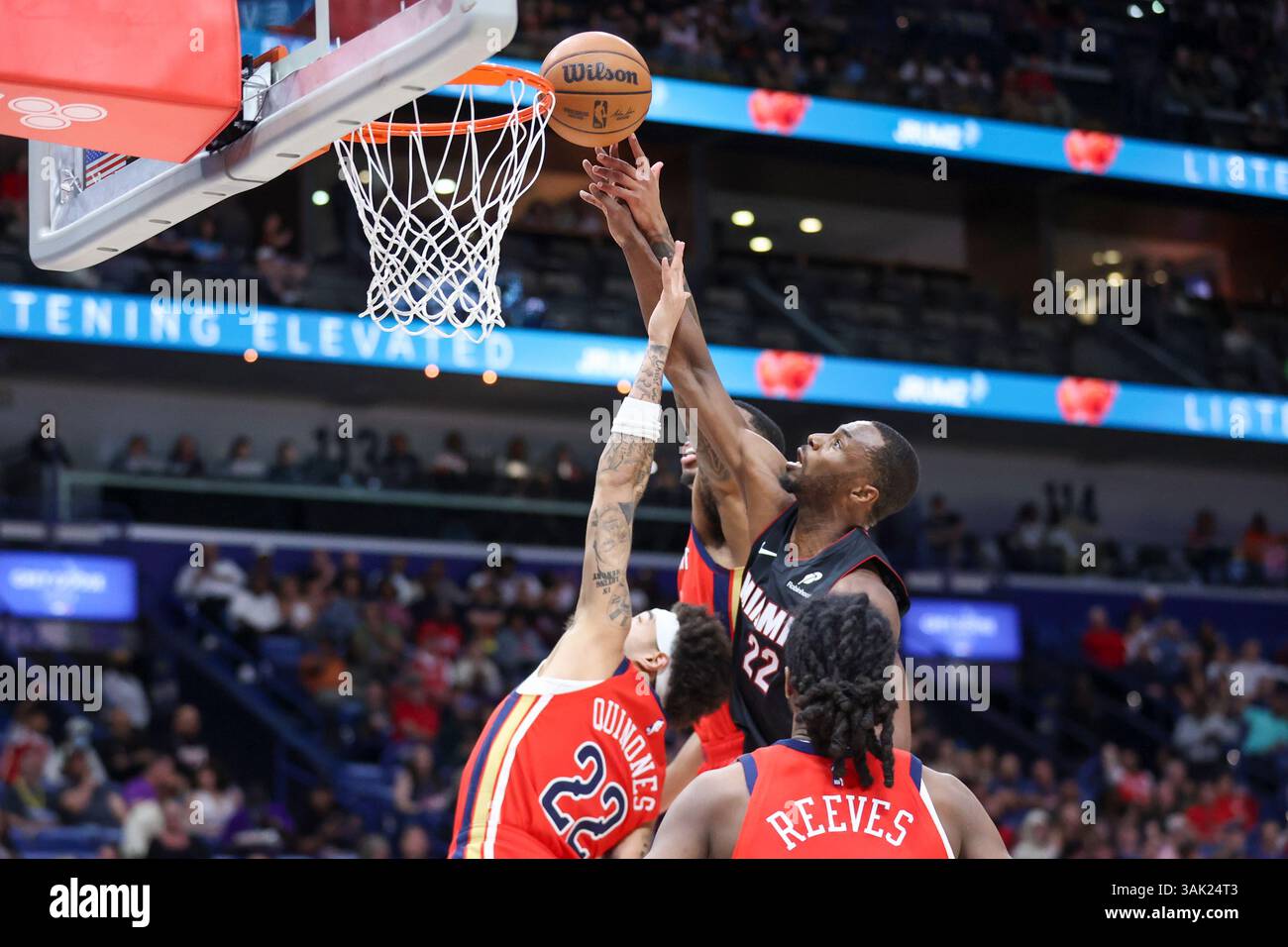 Miami Heat forward Andrew Wiggins (22) tips in a layup between a trio ...