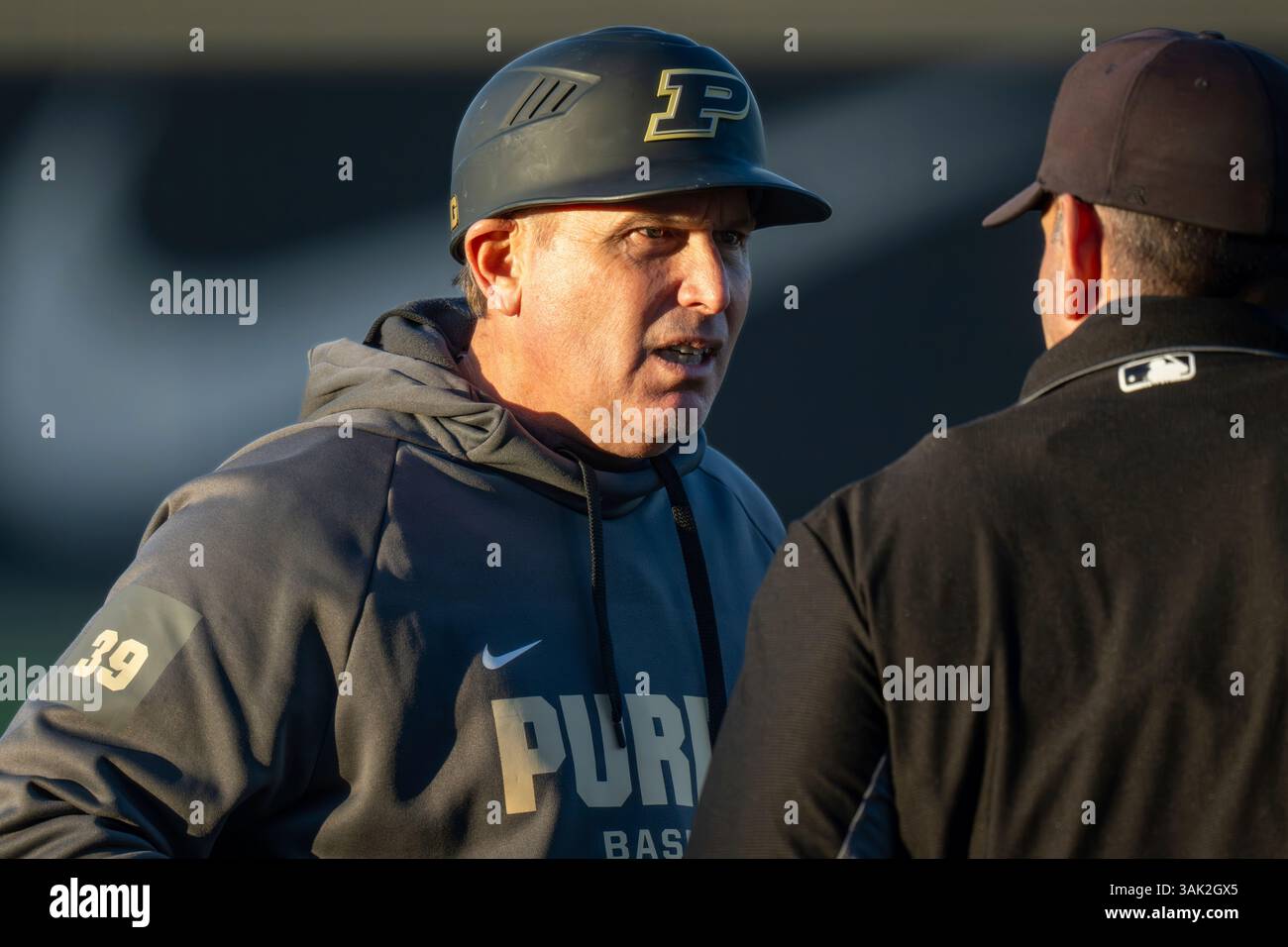 Purdue head coach Greg Goff talks with the plate umpire during an NCAA ...
