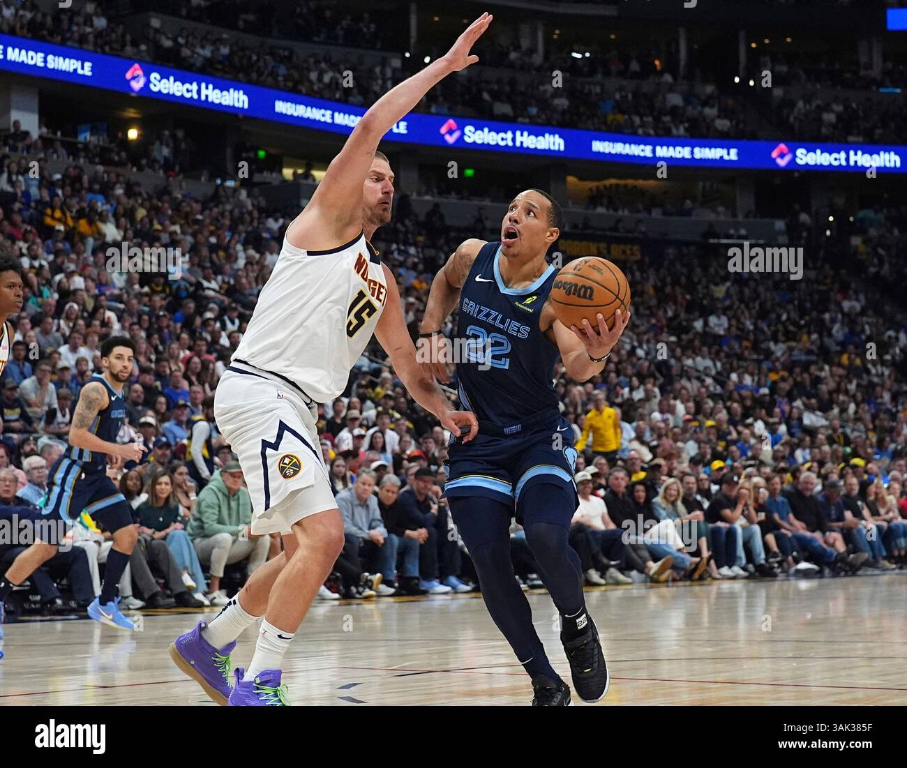 Memphis Grizzlies guard Desmond Bane, right, drives the lane as Denver ...