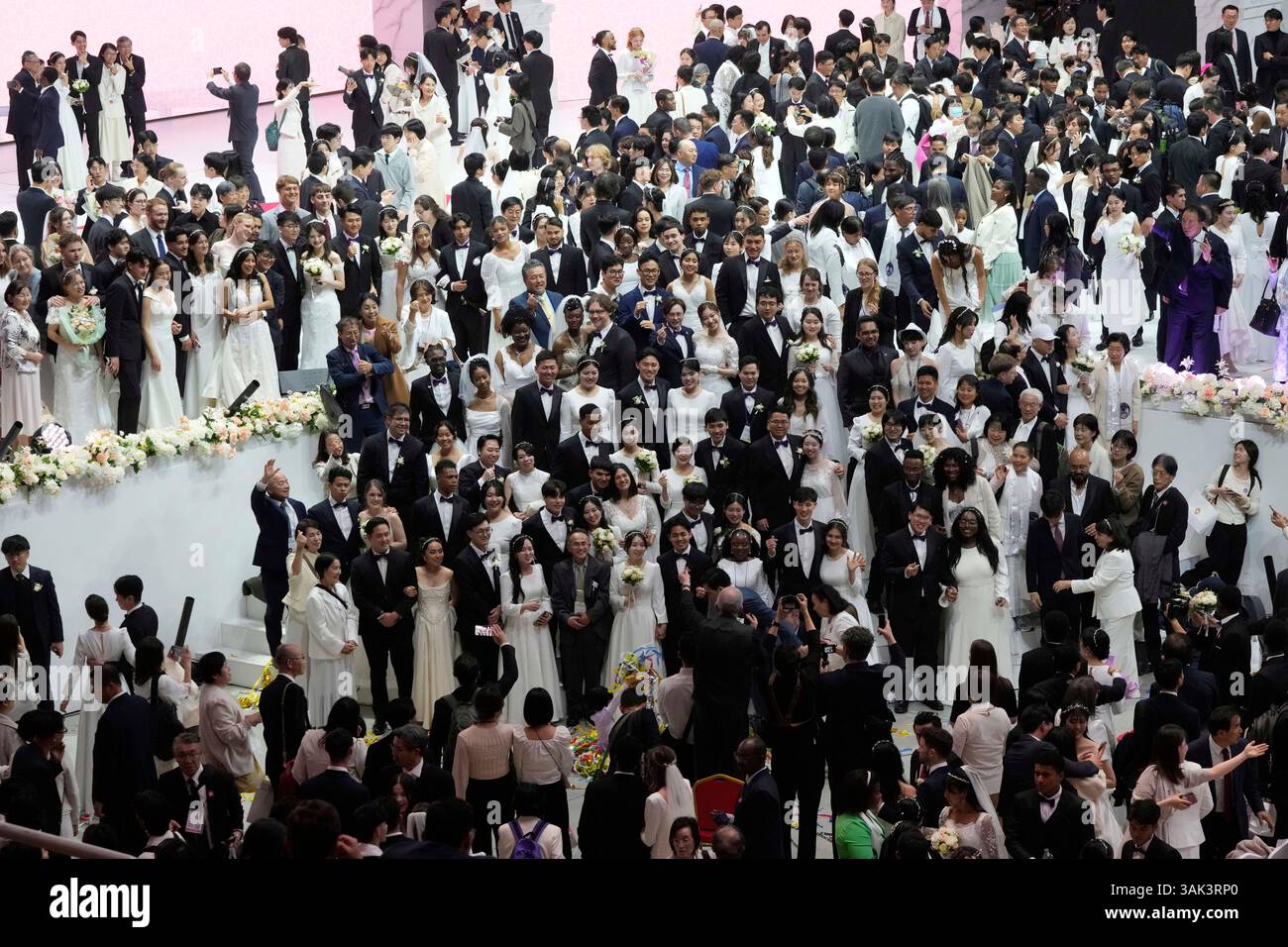 Couples pose for their memorial photos after a mass wedding ceremony at ...