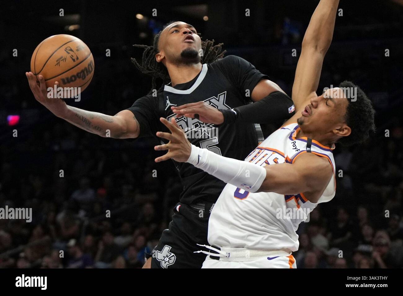 San Antonio Spurs guard Stephon Castle (5) drives on Phoenix Suns forward Ryan Dunn during the ...
