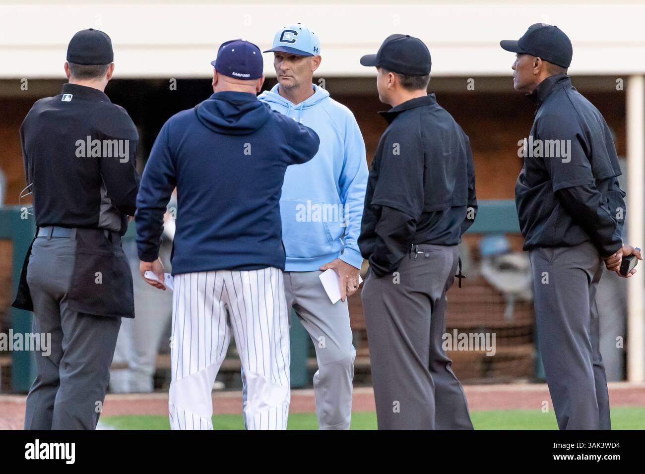 Samford head coach Tony David, in dark blue, talks with the umpires and ...