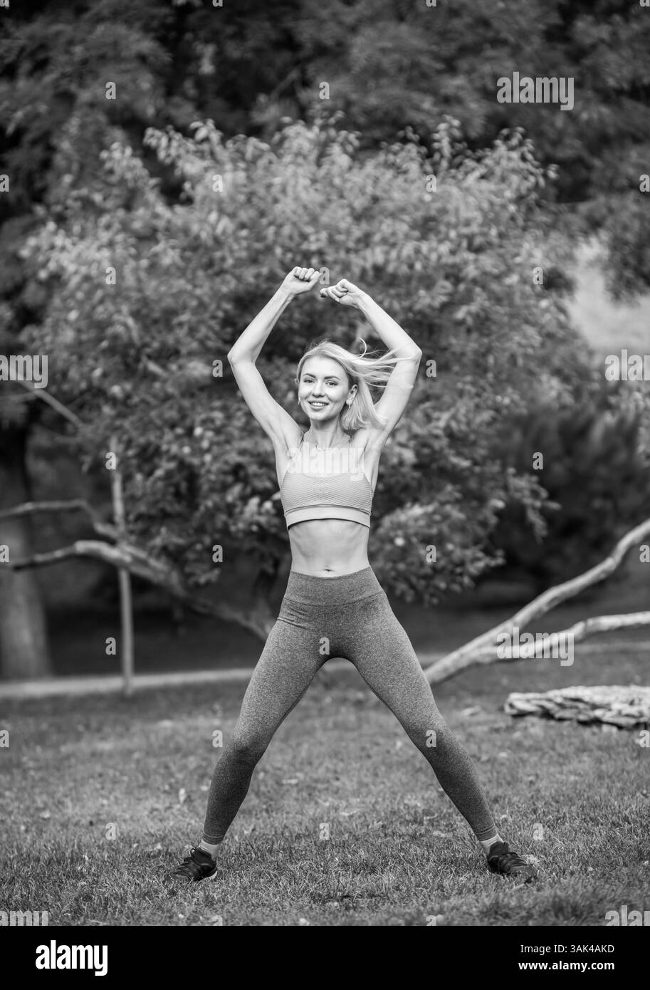 Outdoor training. Young fitness woman doing an aerobic workout before ...