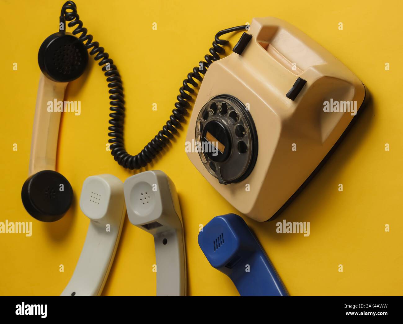 Hotline, office concept. Old rotary telephone, many handsets on yellow ...