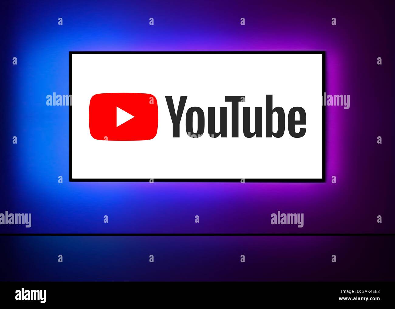 The YouTube logo displayed on a TV screen, with a vibrant neon purple ...