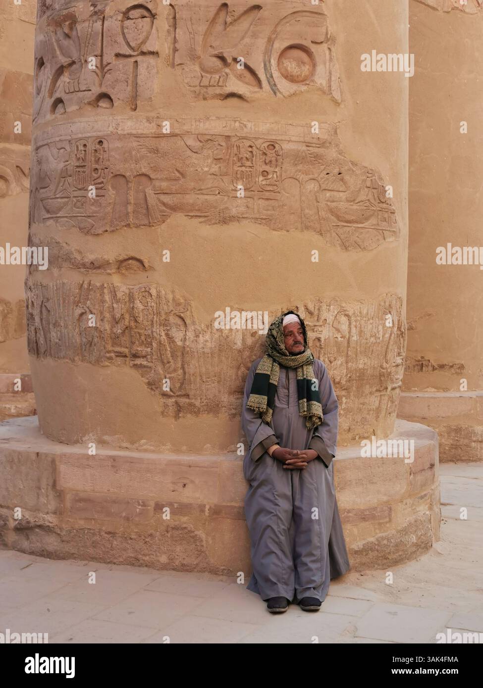 Lonely guide at Karnak Temple in Luxor patiently waits for some ...