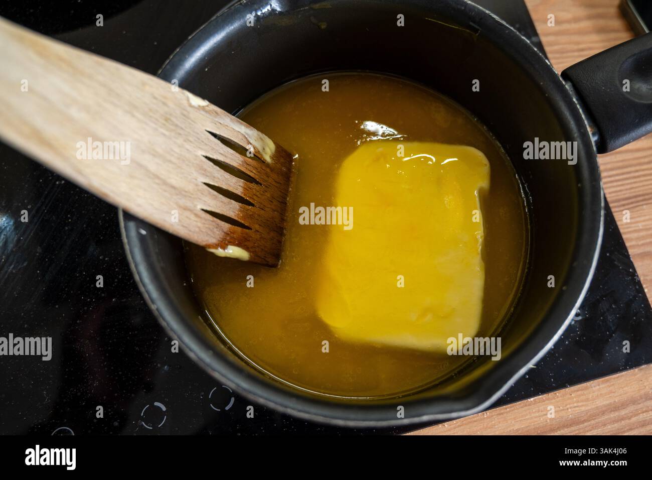 melting cube of butter in a hot pan to make chocolate glaze Stock Photo ...