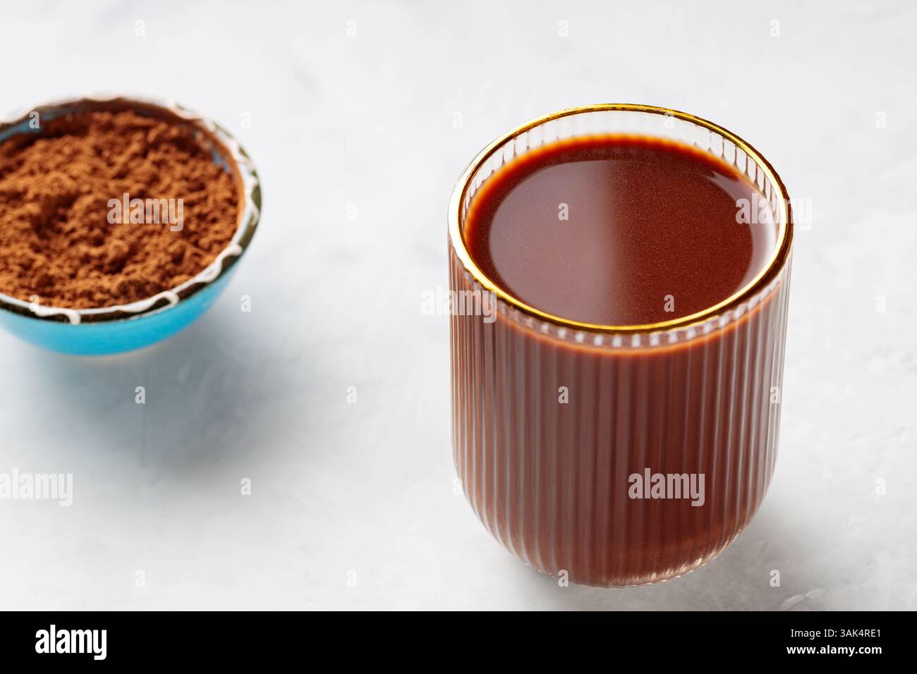 Cocoa Drink in Glass with Gold Rim and Bowl of Cocoa Powder on Gray ...