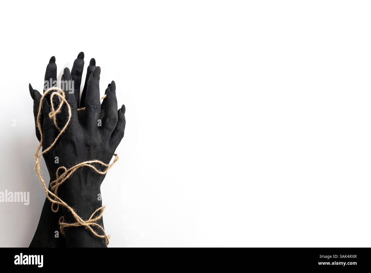 Concept photo with woman hands painted in black paint with a rope ...