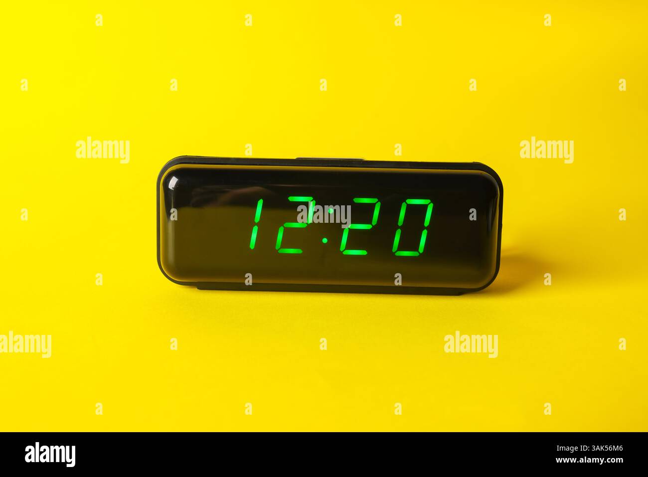 Digital alarm clock showing 12:20 o'clock on yellow background Stock ...