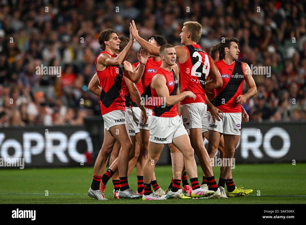 Harrison Jones of Essendon (L) reacts after kicking a goal with team ...