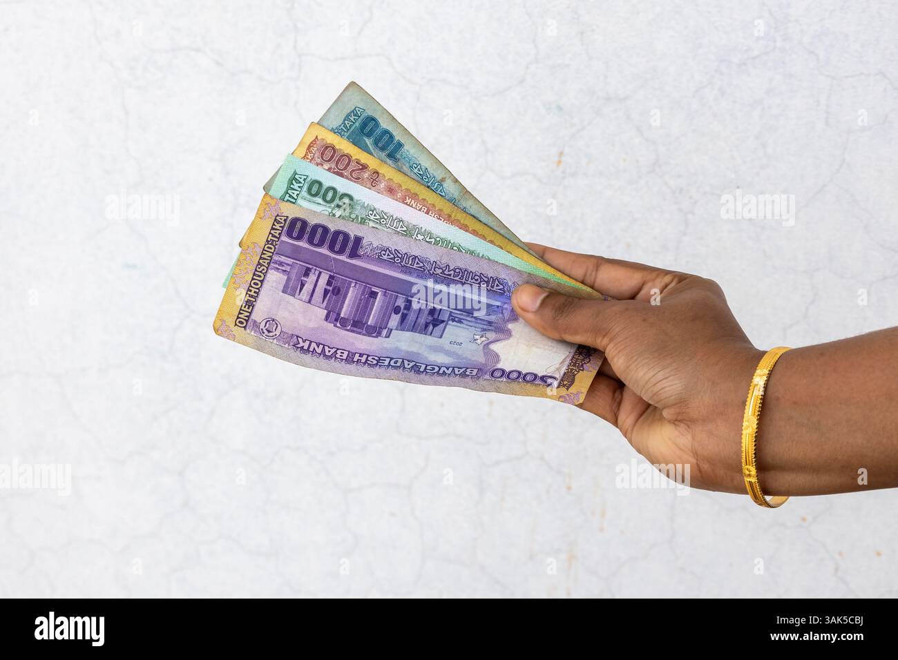 Female hand displaying 1000, 500, 200, and 100 taka Bangladeshi ...