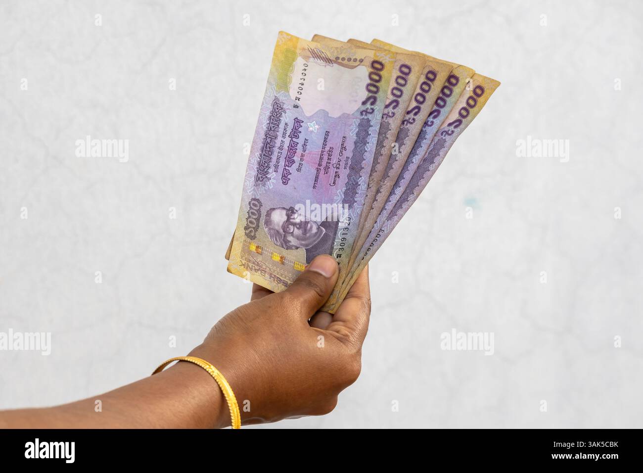 A female hand holds 1000 taka Bangladeshi banknotes (one thousand BDT ...