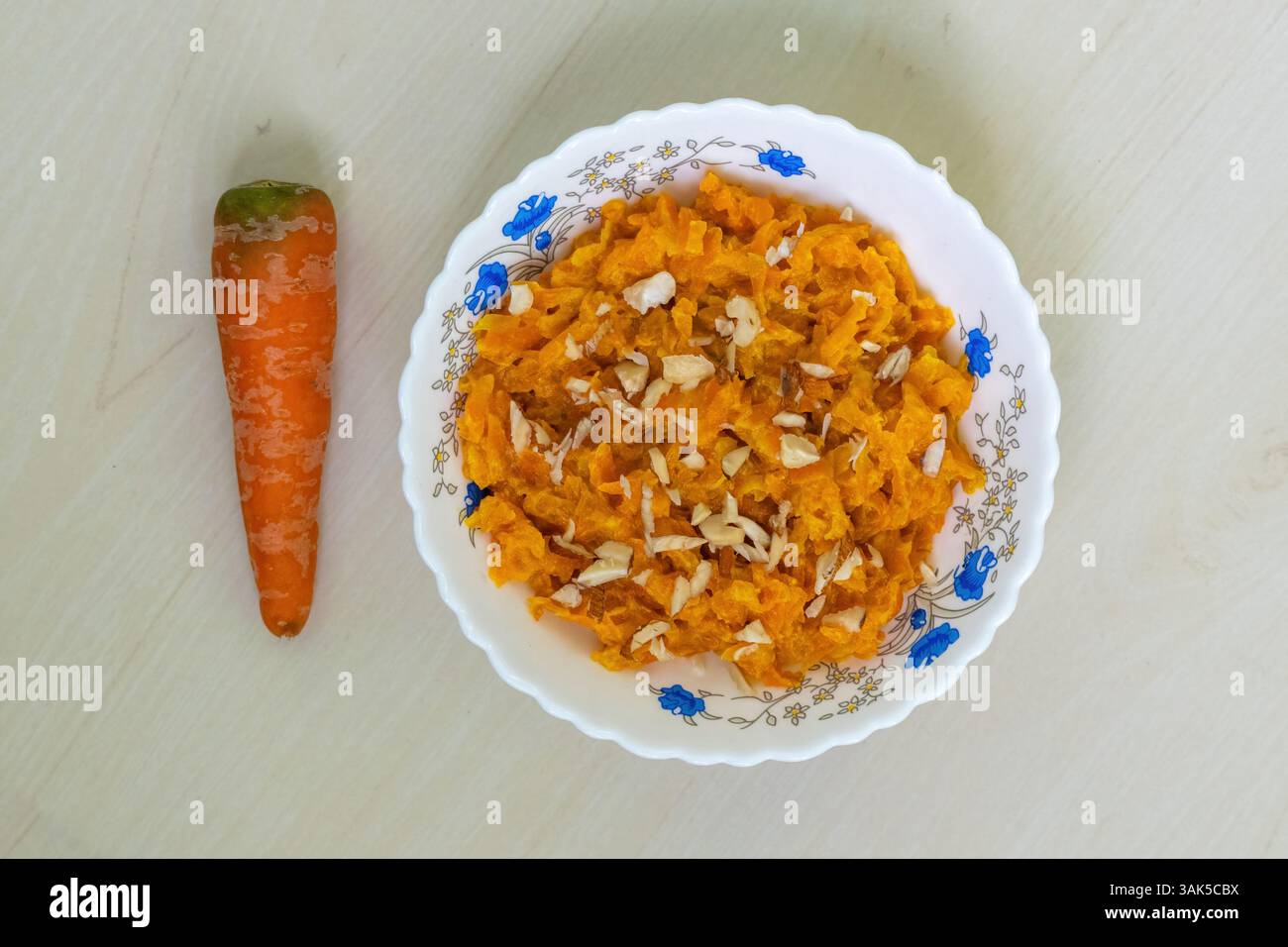 Top view of a white bowl filled with delicious Carrot Halwa, or Gajar ...
