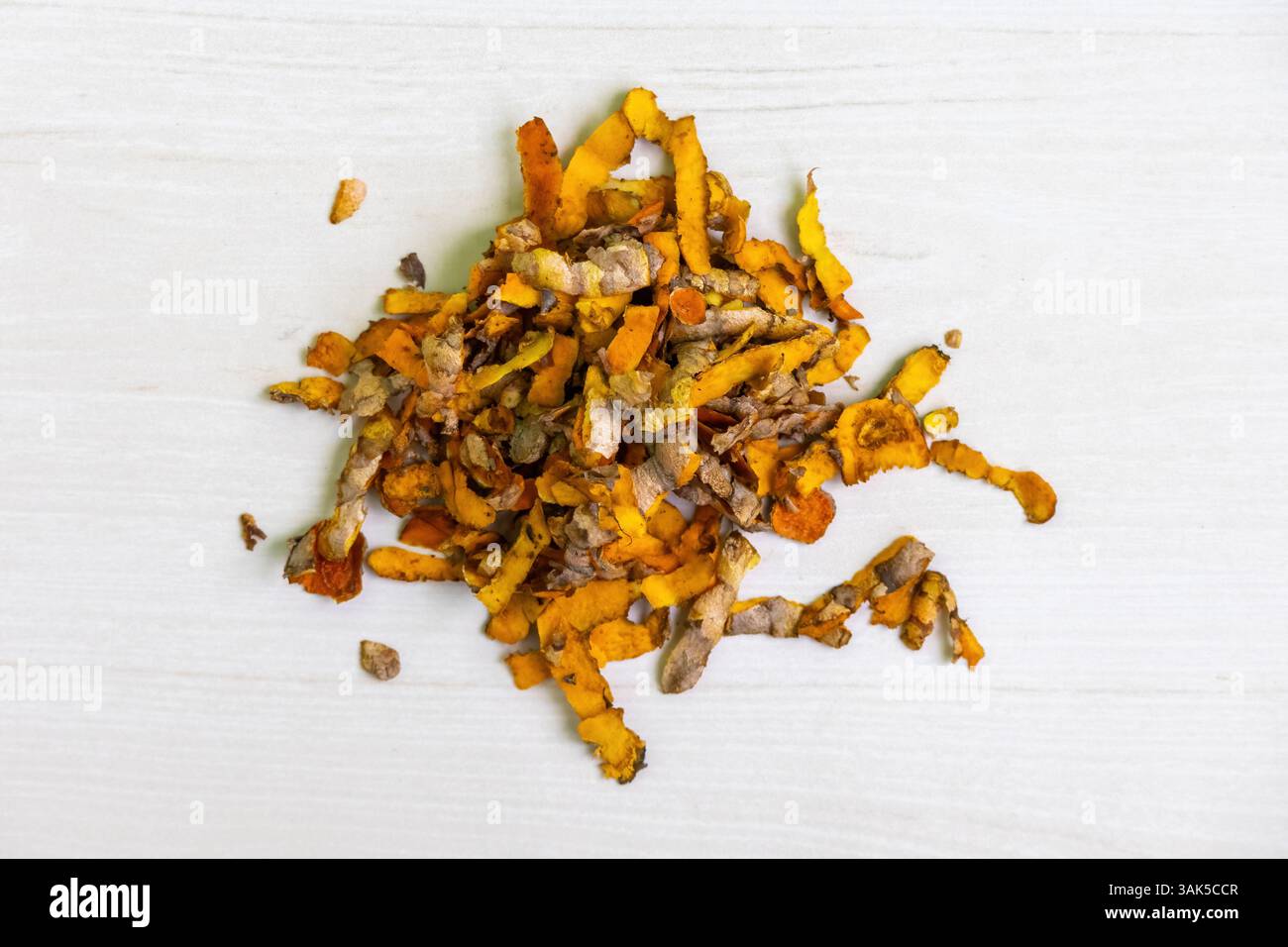 Raw turmeric skins on a light wooden surface are used for skin ...