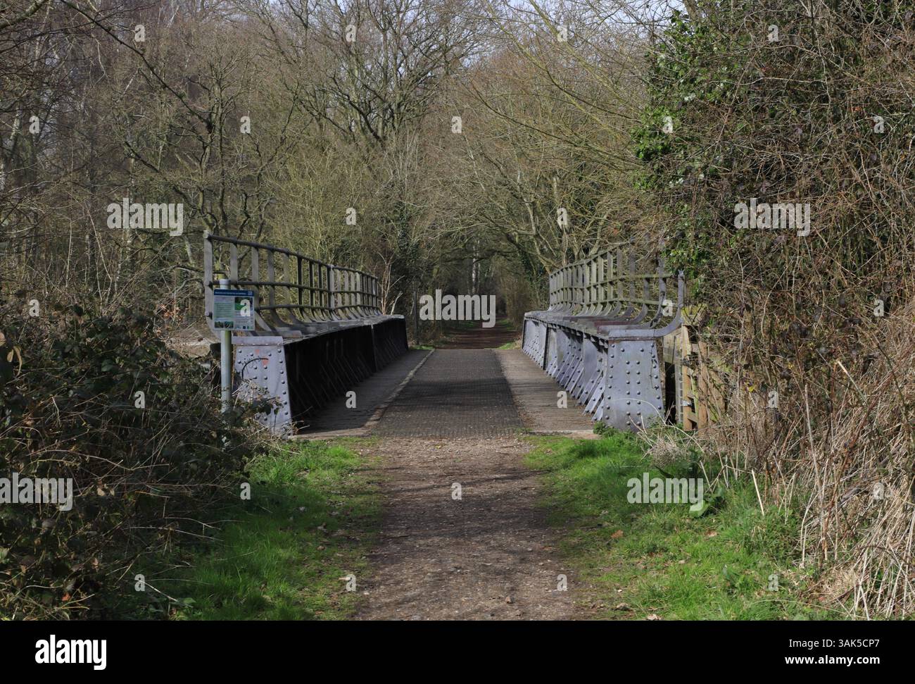 The Marriott's Way long distance track with old railway bridge crossing ...