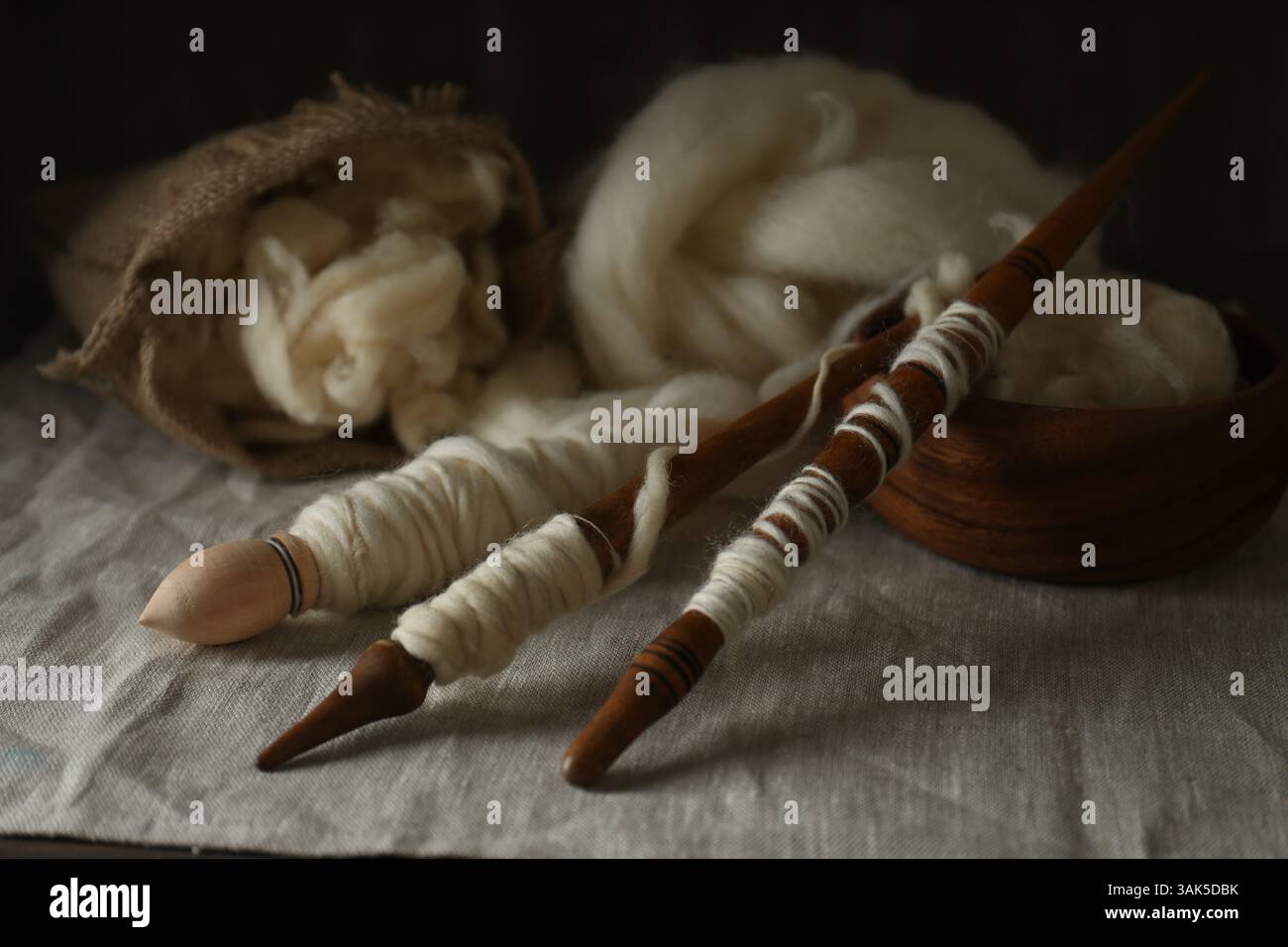 Soft white wool and spindles on table, closeup Stock Photo - Alamy