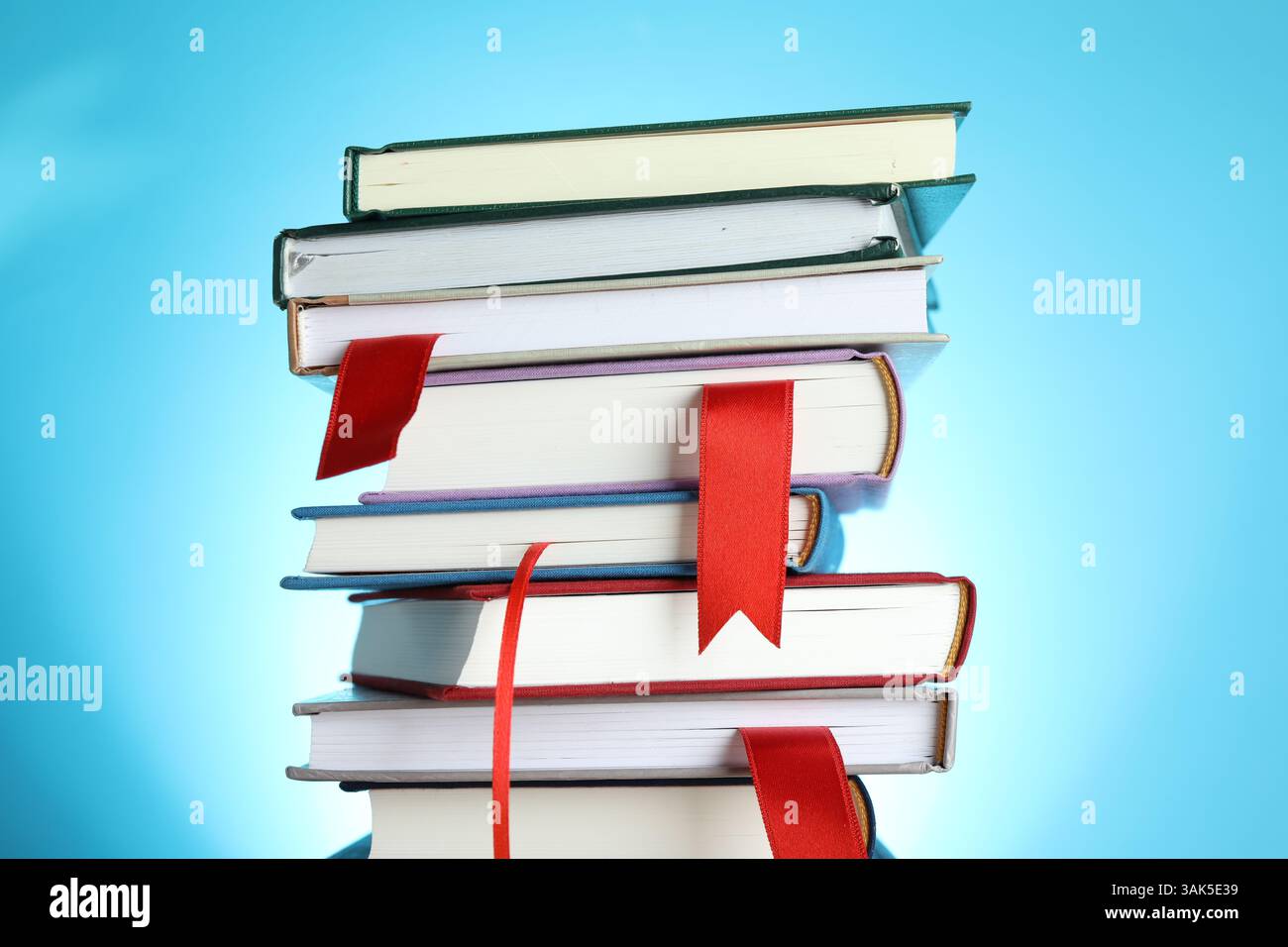 Books with red ribbon bookmarks on light blue background, closeup Stock ...