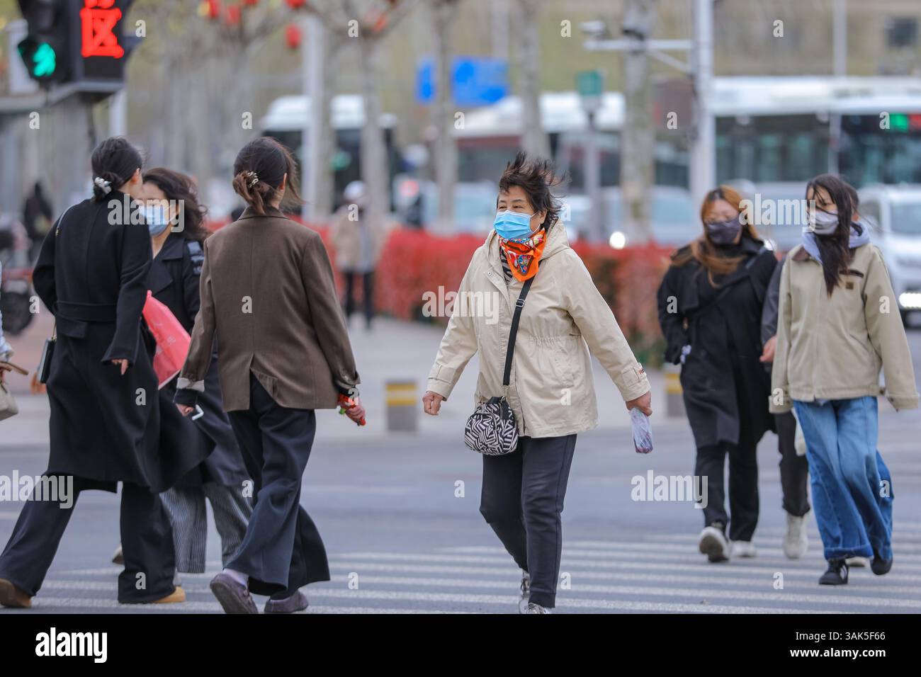 Beijing, China's Shandong Province. 12th Apr, 2025. People walk in the ...