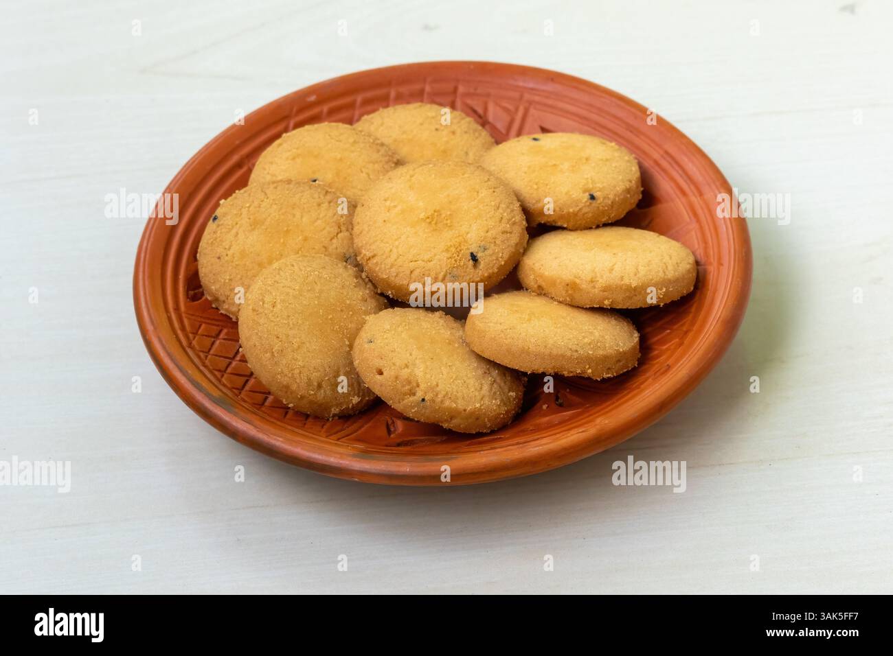 Delicious, salty cookies biscuits on a clay plate, set against a wooden ...