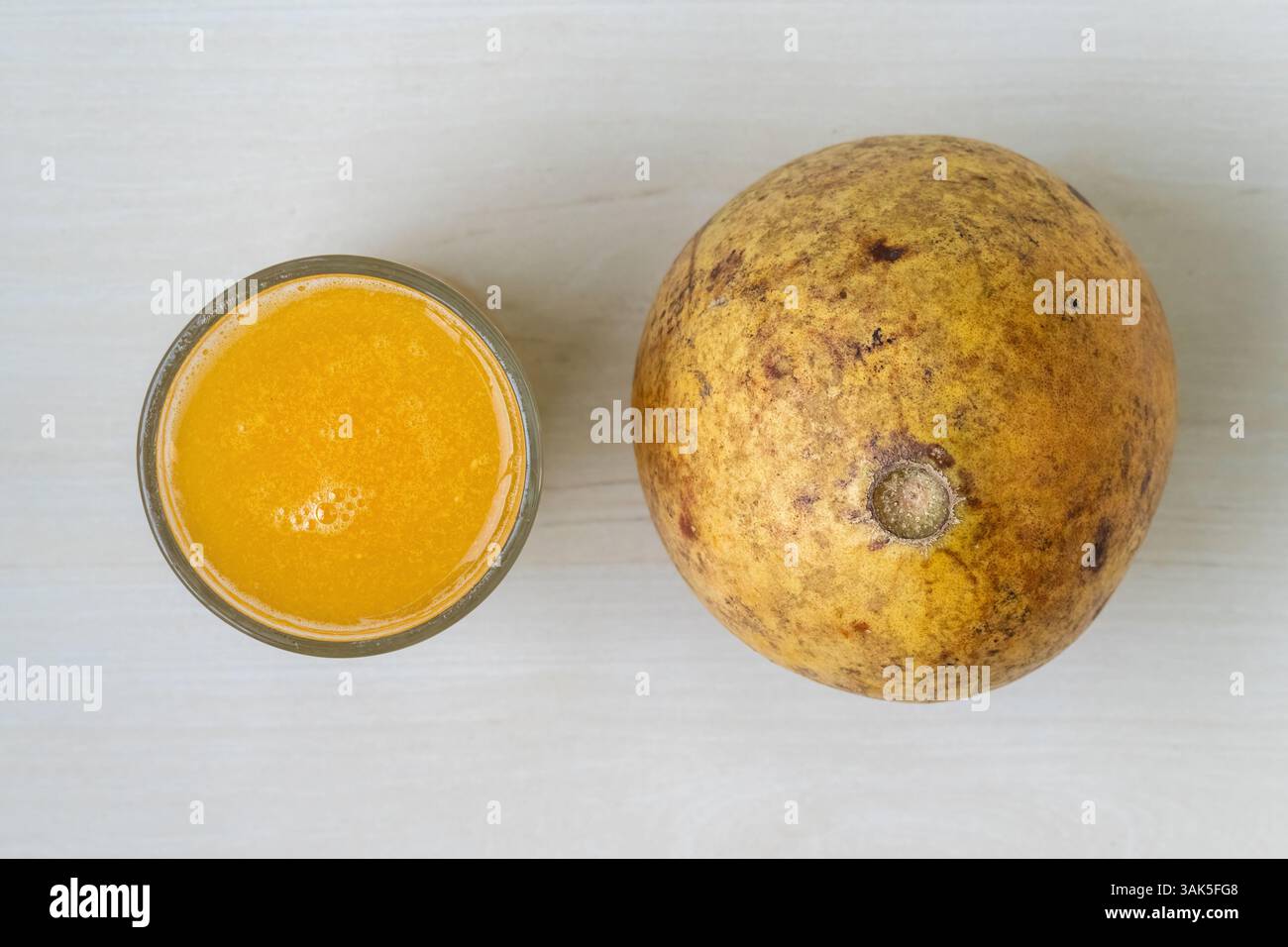 Top view of a glass of ripe bael fruit juice or Sharbat (Aegle marmelos ...