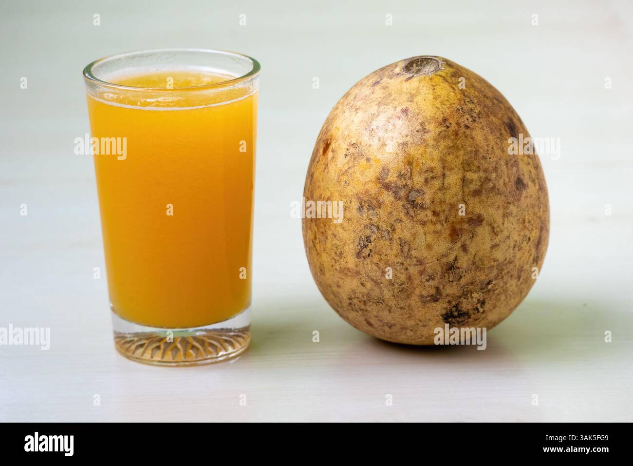 Ripe bael fruit juice, also known as Sharbat, in a glass. Its ...