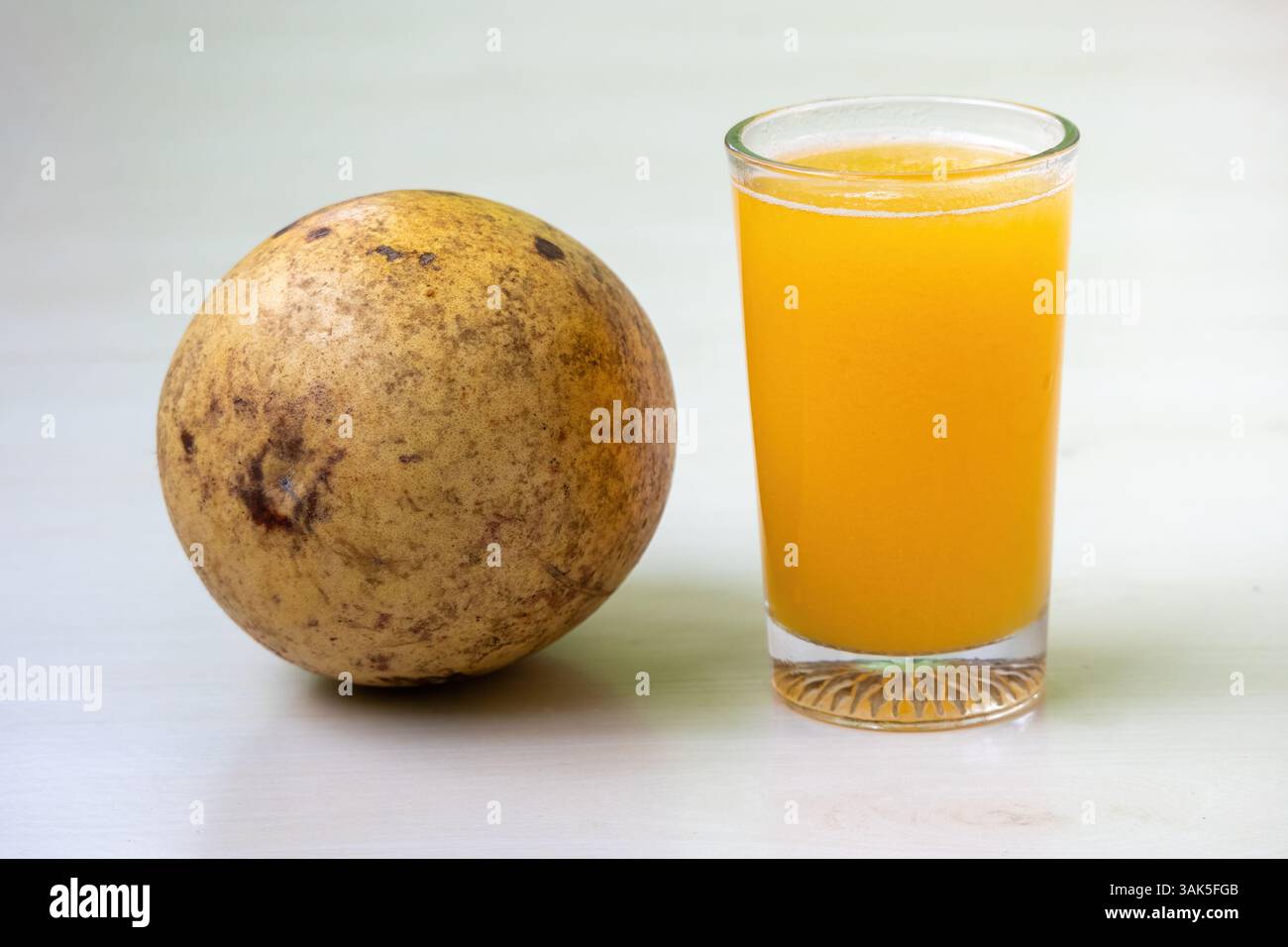 Ripe bael fruit juice, or Sharbat, in a glass. Its scientific name is ...