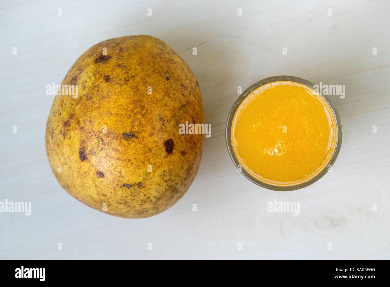 From a top view, a glass contains ripe bael fruit juice, also called ...