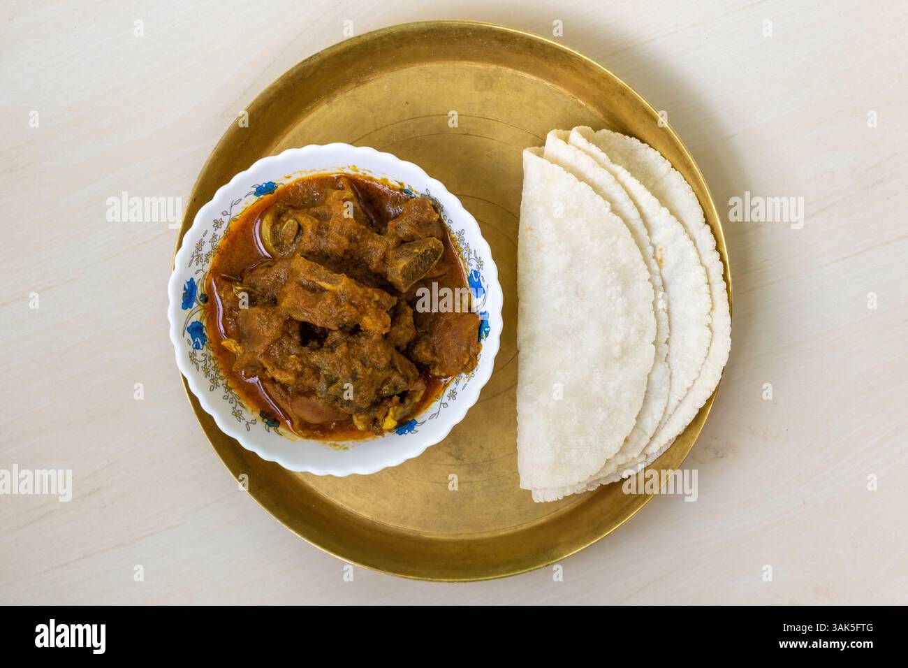 Tasty mutton curry and roti (flatbread) served on a brass plate on a ...