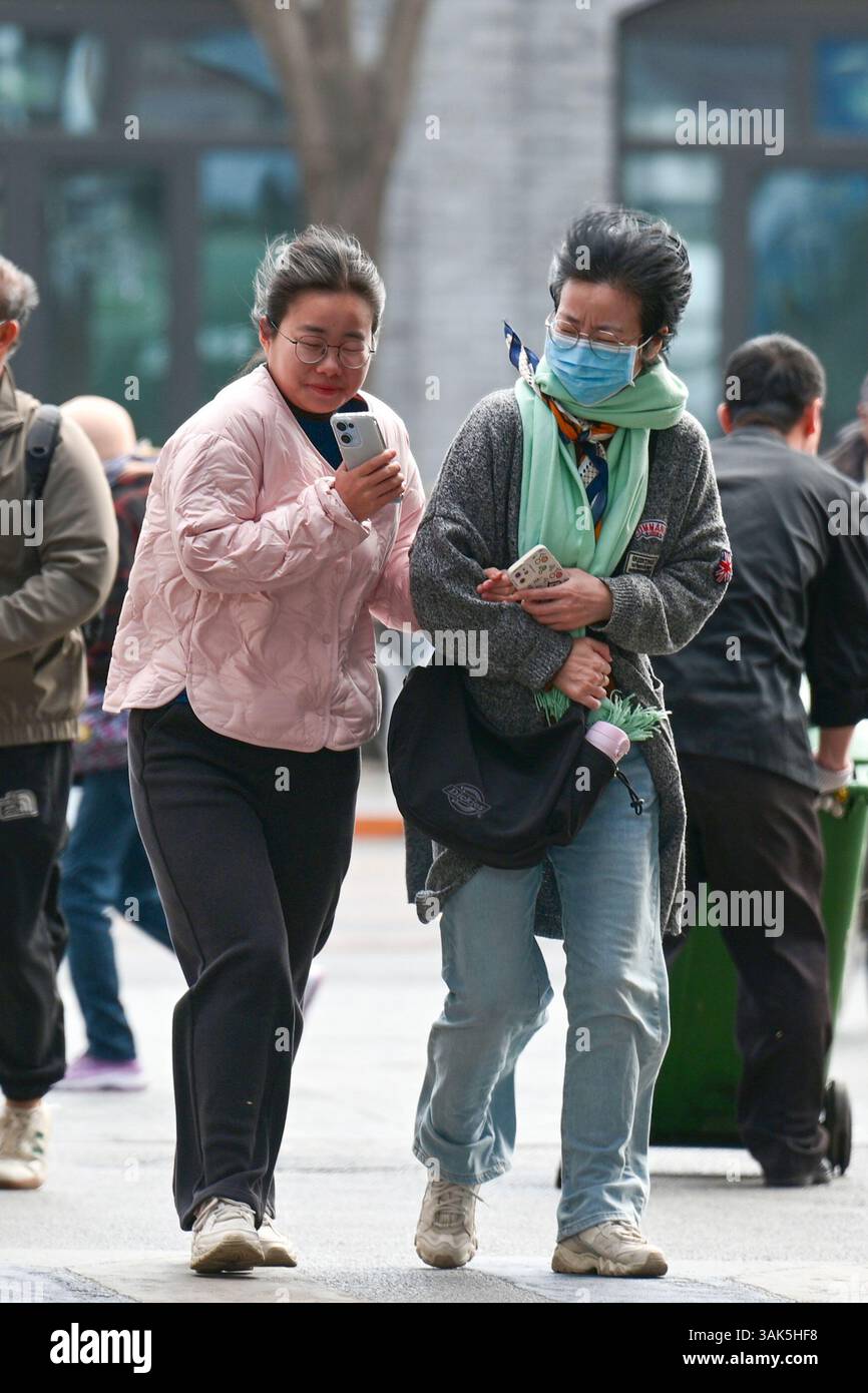 Beijing, China. 12th Apr, 2025. People walk on a street in Beijing ...